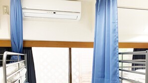 Quarto com beliche, ar condicionado e cortinas.