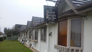 Fileira de casas móveis brancas com uma placa indicando Tudor Goose Motor Inn.