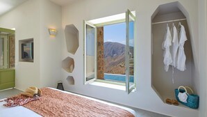 Quarto com uma janela grande, uma cama com manta estampada, um chapéu e uma cesta.