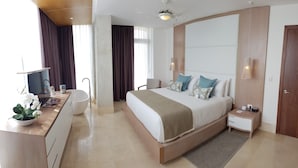 Quarto de hotel moderno com uma cama grande, uma escrivaninha com um computador, uma pia e um vaso de planta.