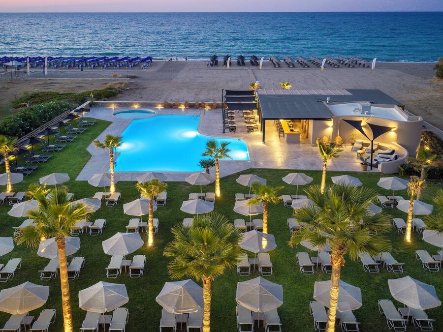 Resort com piscina, cadeiras de praia, guarda-sóis e área de refeições.