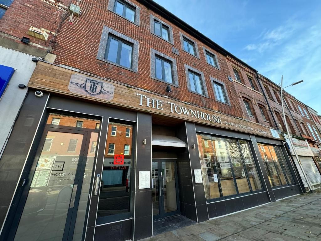 Edifício de tijolos com placa indicando 'The Townhouse Bar Kitchen Lounge'.