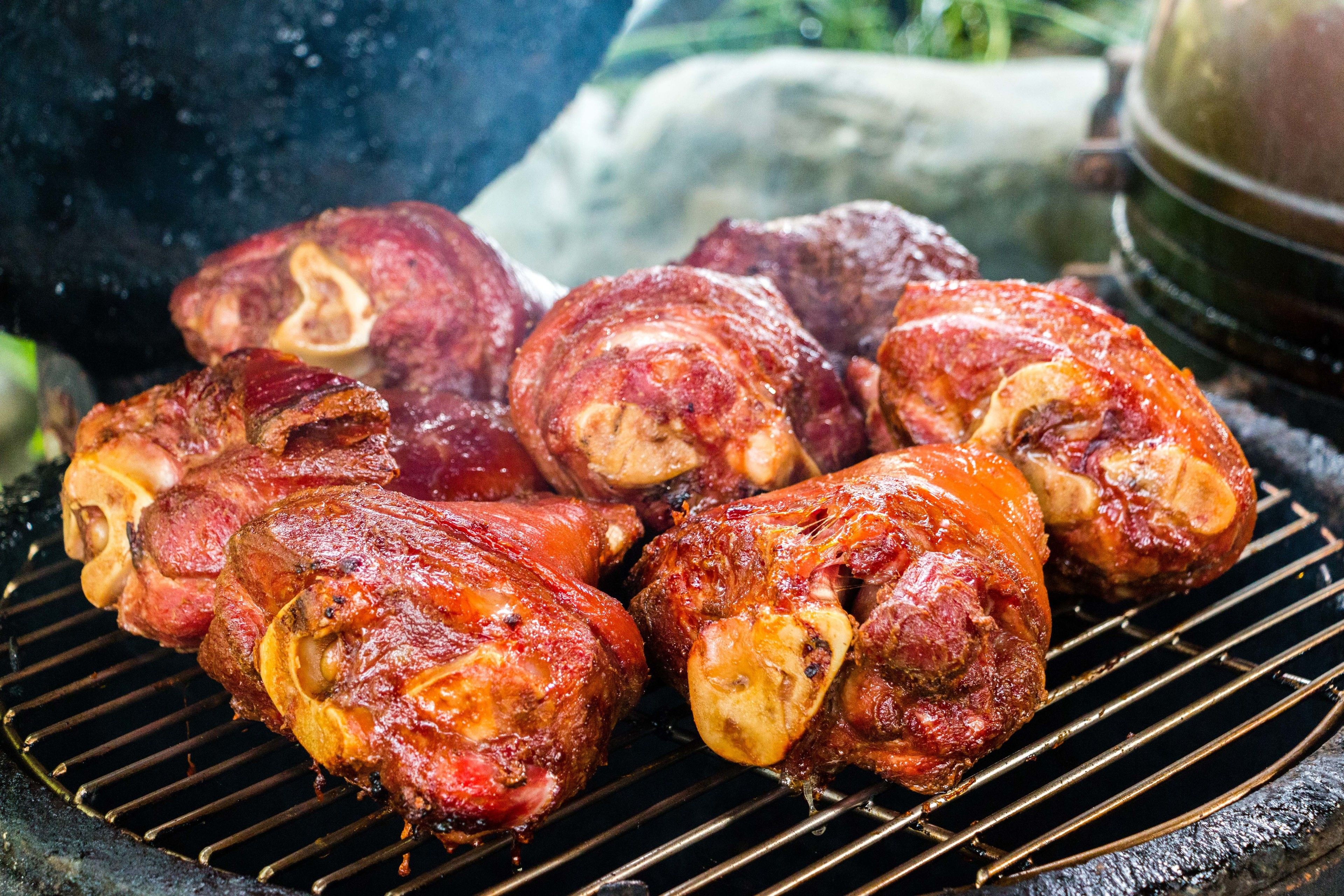 Uma churrasqueira com vários pedaços de carne sendo assados.