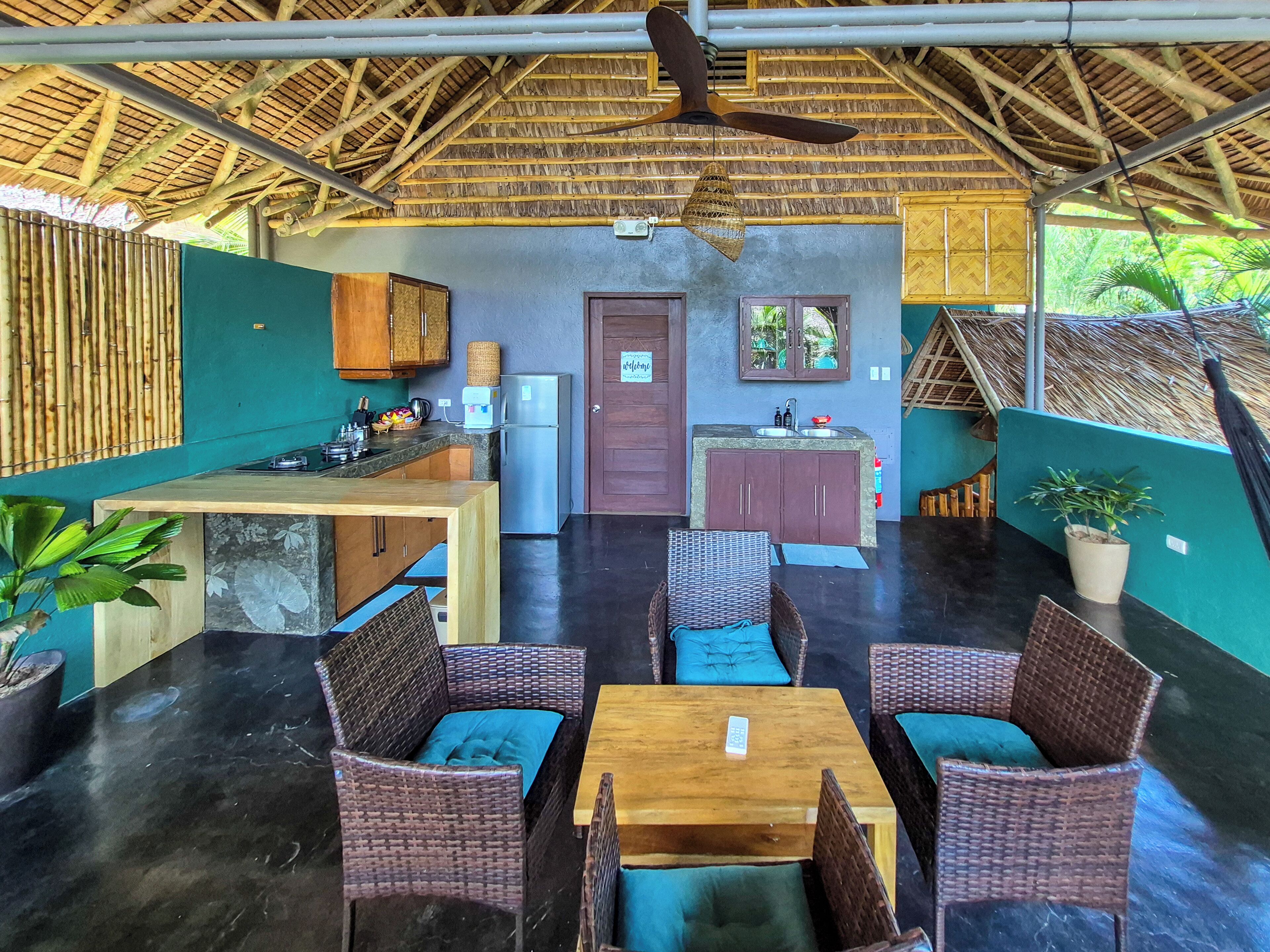 Quarto com cozinha, sala de jantar e ventoinha no teto.