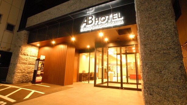 Exterior do ABHOTEL com design moderno, apresentando fachada de pedra e entrada de vidro.