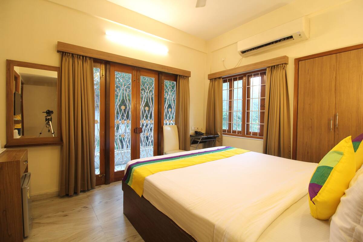 Quarto de hotel com uma cama grande, uma escrivaninha e um guarda-roupa.