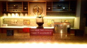Uma área de bar com um letreiro que diz 'Você tem duas opções: pegue ou deixe' e uma máquina de café.