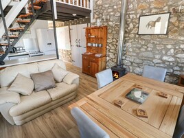 Uma sala de estar aconchegante com sofá, mesa de centro de madeira e parede de pedra.