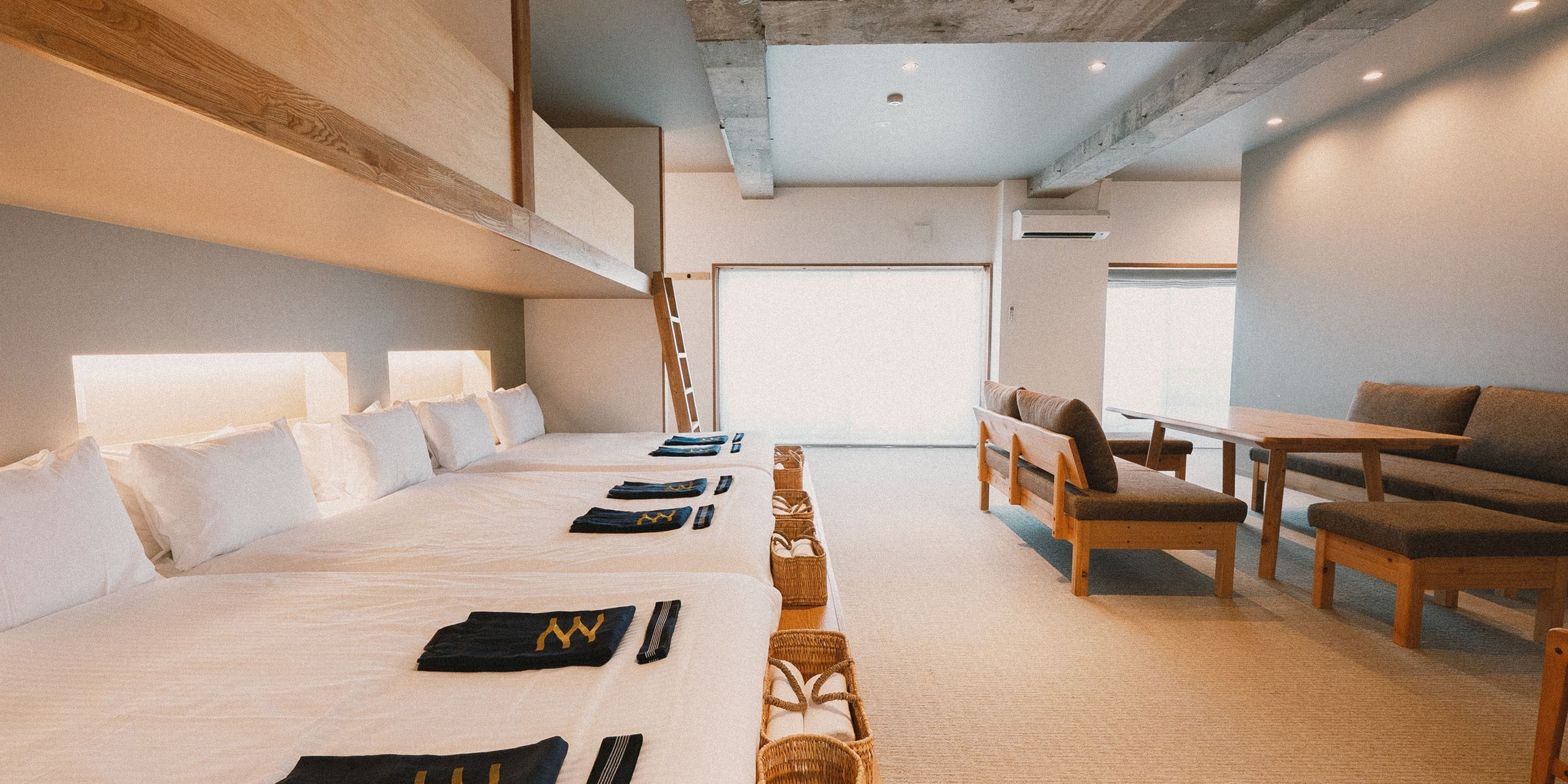 Quarto de hotel moderno com uma cama grande, uma mesa e um espaço de estar.