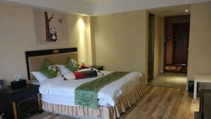 Quarto de hotel com cama grande, mesa de cabeceira e uma obra de arte na parede.