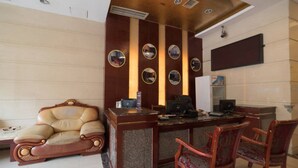 Um hall de entrada com uma mesa de recepção, um sofá e duas cadeiras.