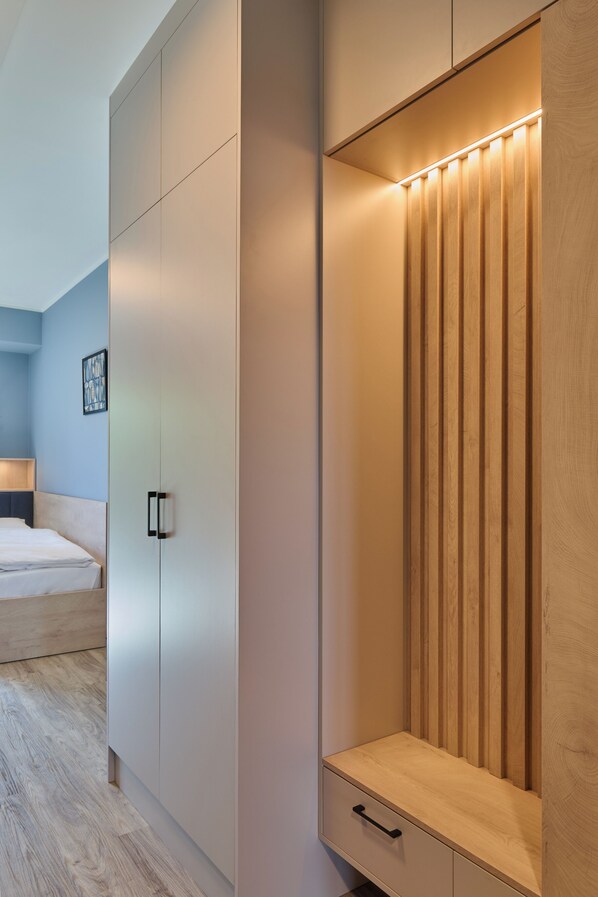 Quarto moderno com um guarda-roupa espaçoso, mesa de cabeceira e uma luminária.