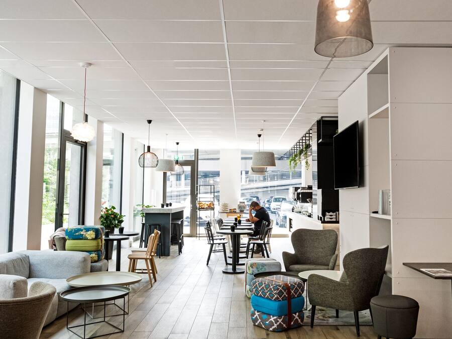 Um interior moderno com um longo corredor, áreas de estar e um bar.