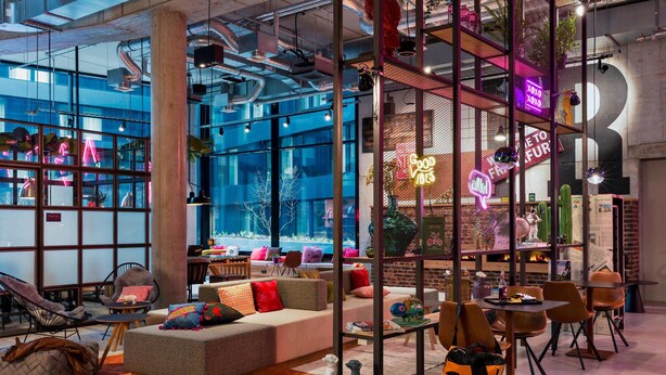 Espaço lounge moderno com sofá, cadeiras e mesa de centro.