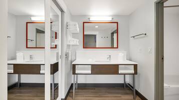 Casa de banho moderna com duas pias, um espelho grande e um porta-toalhas.