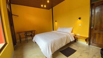 Um quarto com uma cama, uma escrivaninha e uma cadeira.
