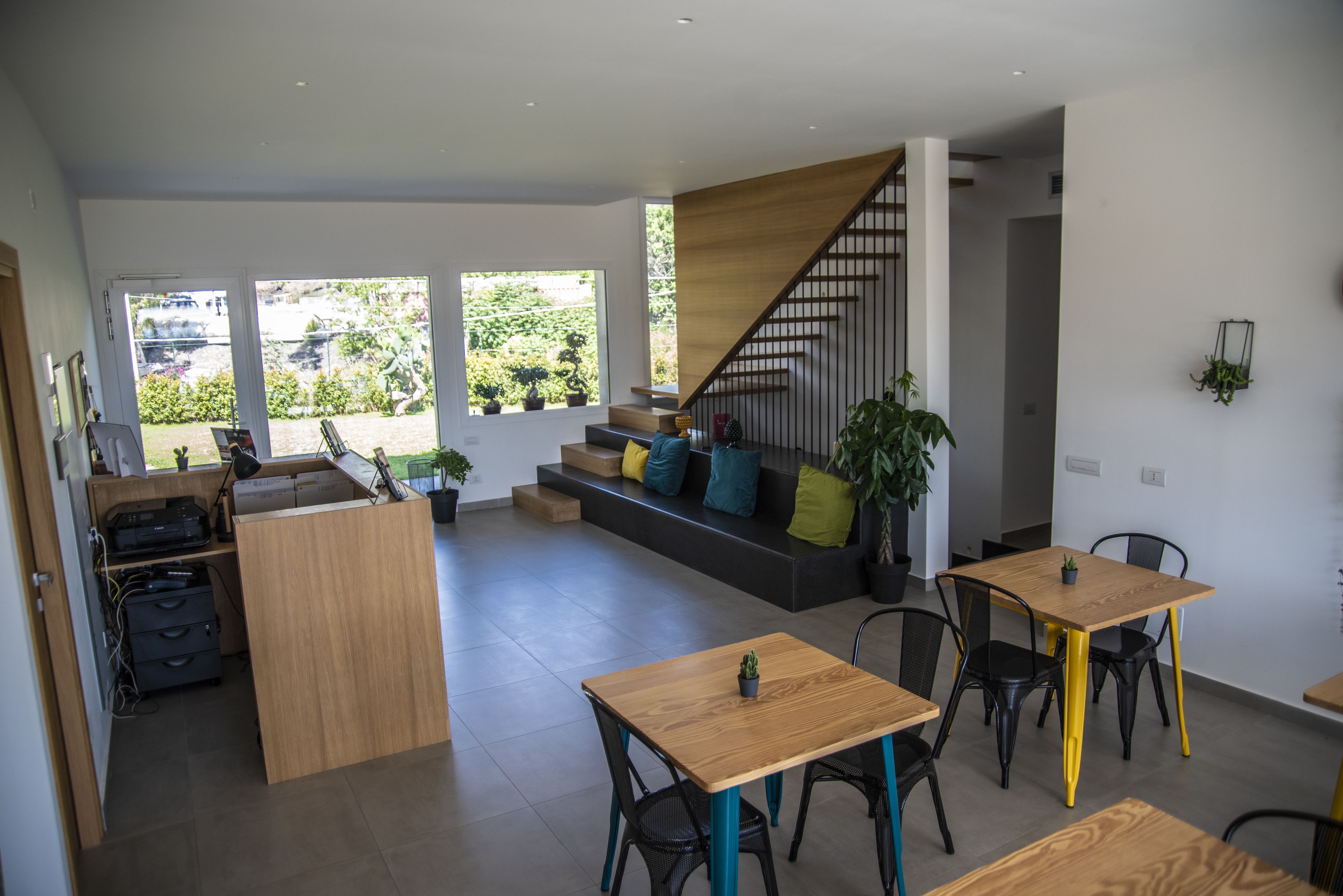 Um interior moderno com cozinha, sala de jantar e escada.