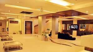 Um hall amplo com design moderno, apresentando uma escada, área de estar e uma tela de televisão.