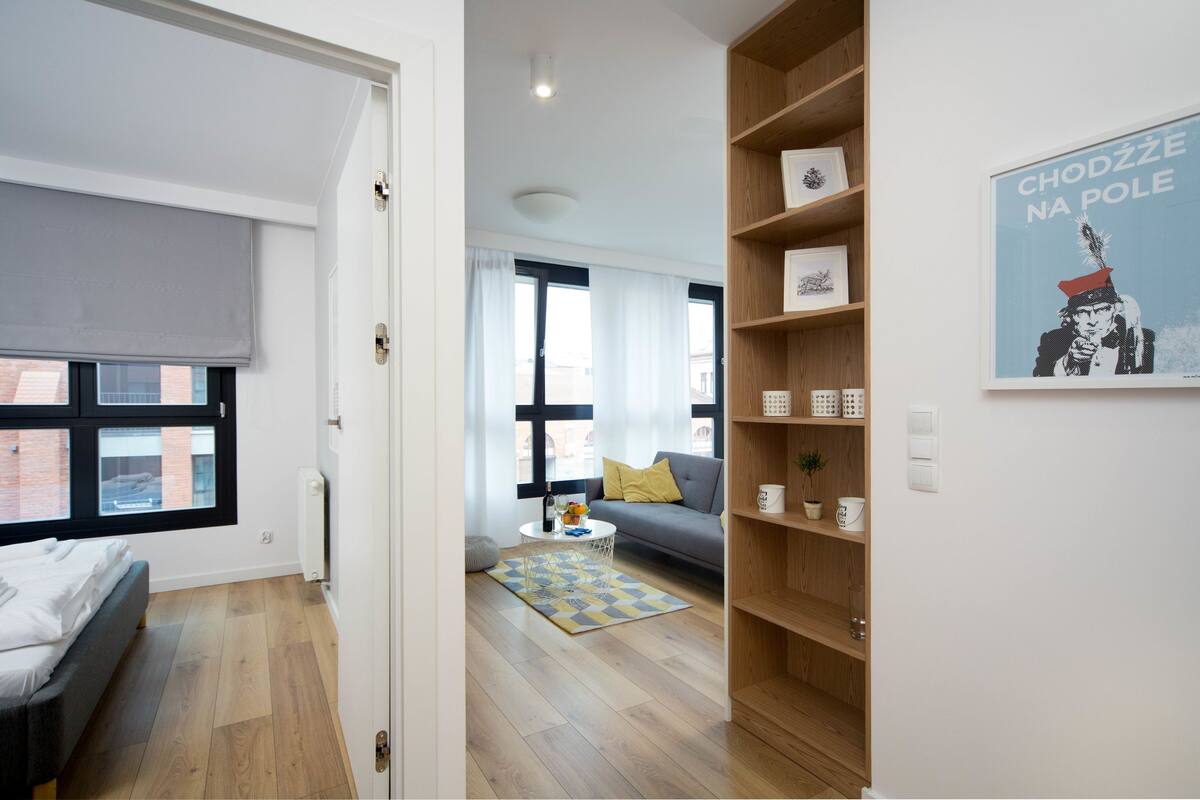 Uma sala de estar moderna com um sofá, uma mesa de centro e uma estante.