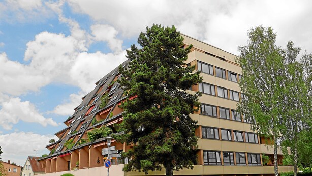 Um edifício com vários andares e design arquitetônico moderno, com varandas e uma variedade de estilos de janelas.