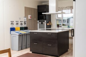 Um frigorífico no espaço comum, um micro-ondas, uma placa de cozinha 