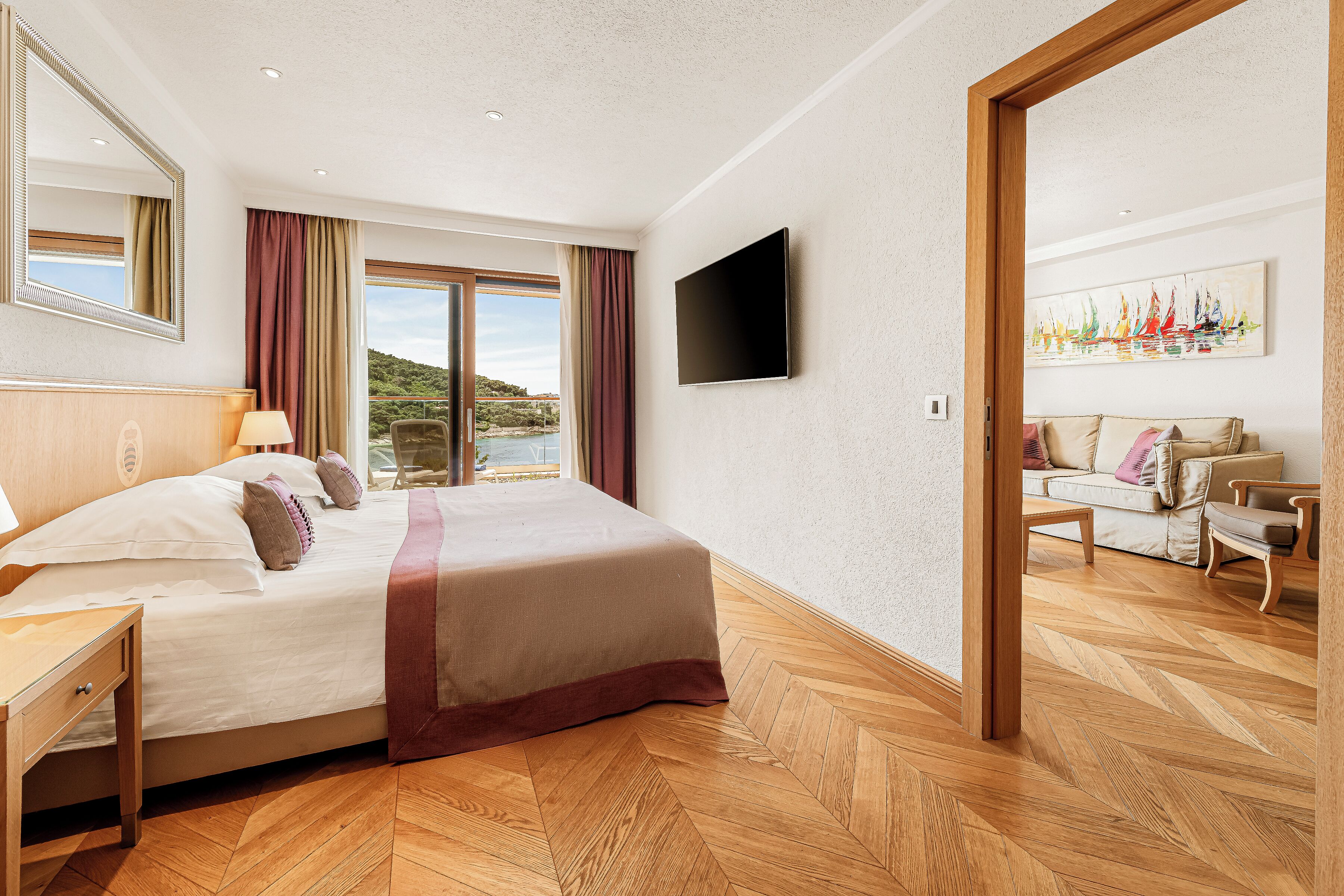 Quarto de hotel com cama, secretária, televisão e vista para o exterior.