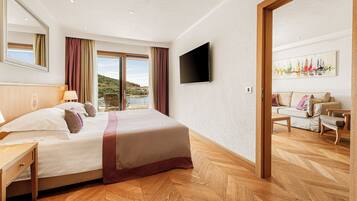 Quarto de hotel com cama, secretária, televisão e vista para o exterior.