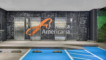 Um elevador moderno com uma grande logo laranja e o texto 'Fiesta Americana' na parede.