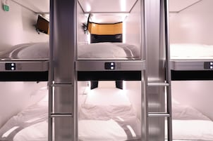 Um vagão de trem com beliches, cada cama numerada 305, 306, 307 e 308.