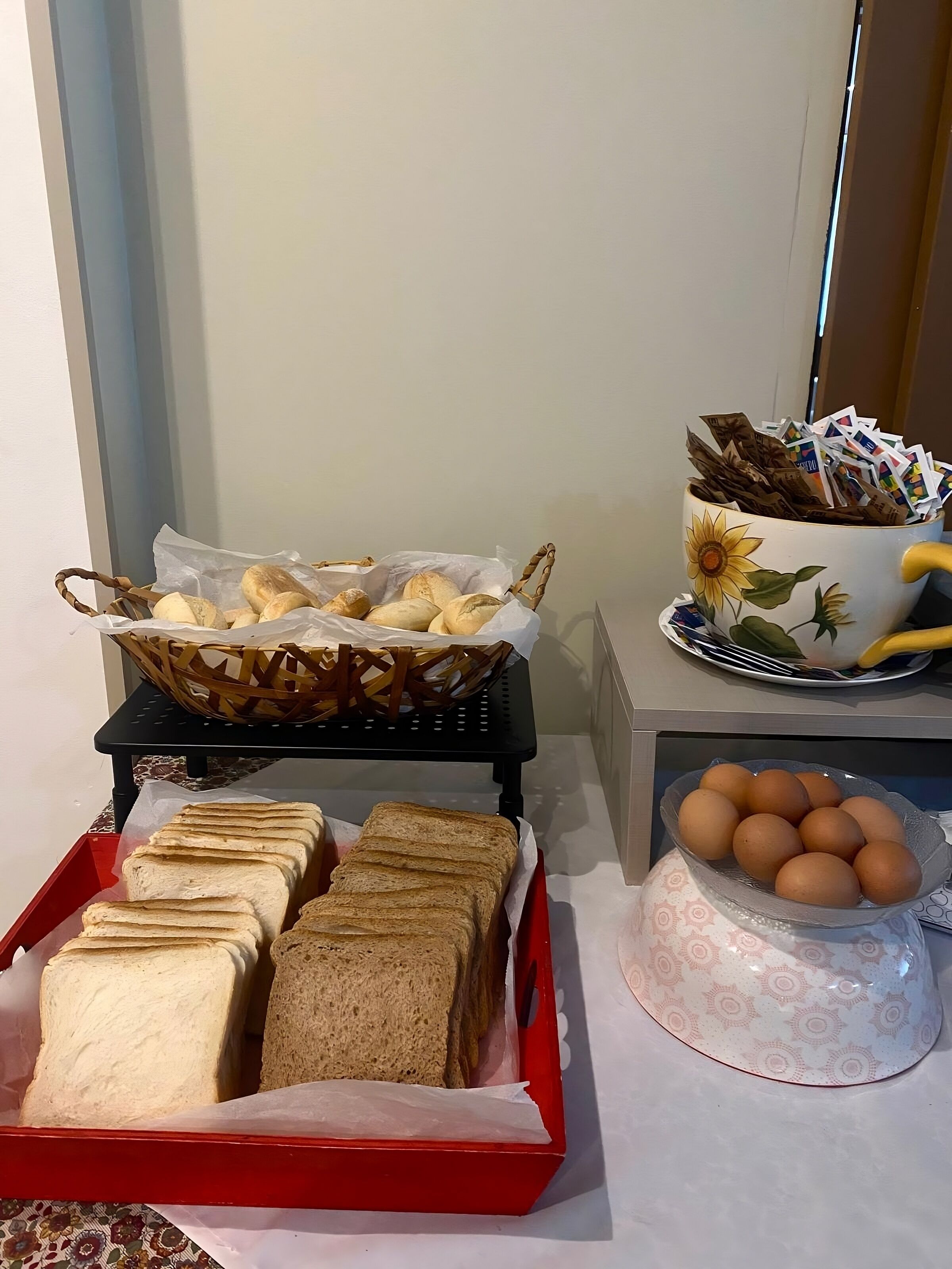 Um buffet de café da manhã com pães, doces e ovos.
