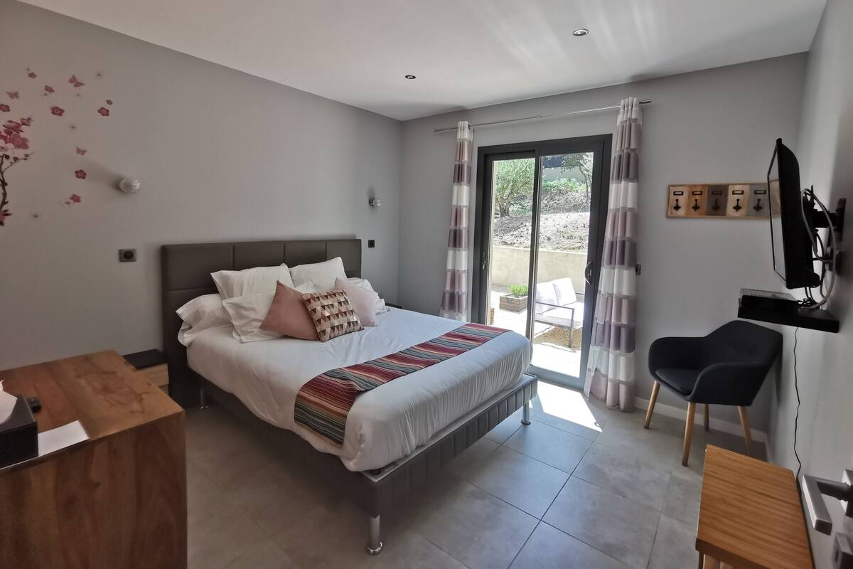 Quarto moderno com cama, escrivaninha e cadeira.