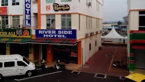 Um edifício de dois andares com uma placa indicando o Hotel River Side.