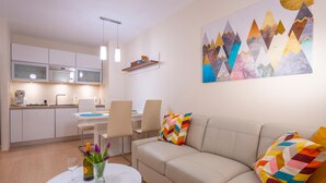 Uma sala de estar moderna com sofá, uma mesa de centro e uma área de jantar com cadeiras.