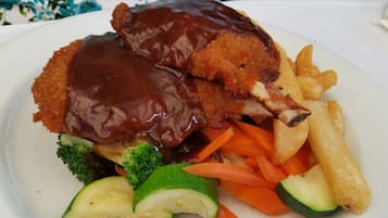 Um prato com frango à milanesa, purê de batatas, cenouras e batatas fritas.