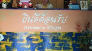 Uma mesa de recepção com uma placa que diz 'Welcome to Viengfa'.