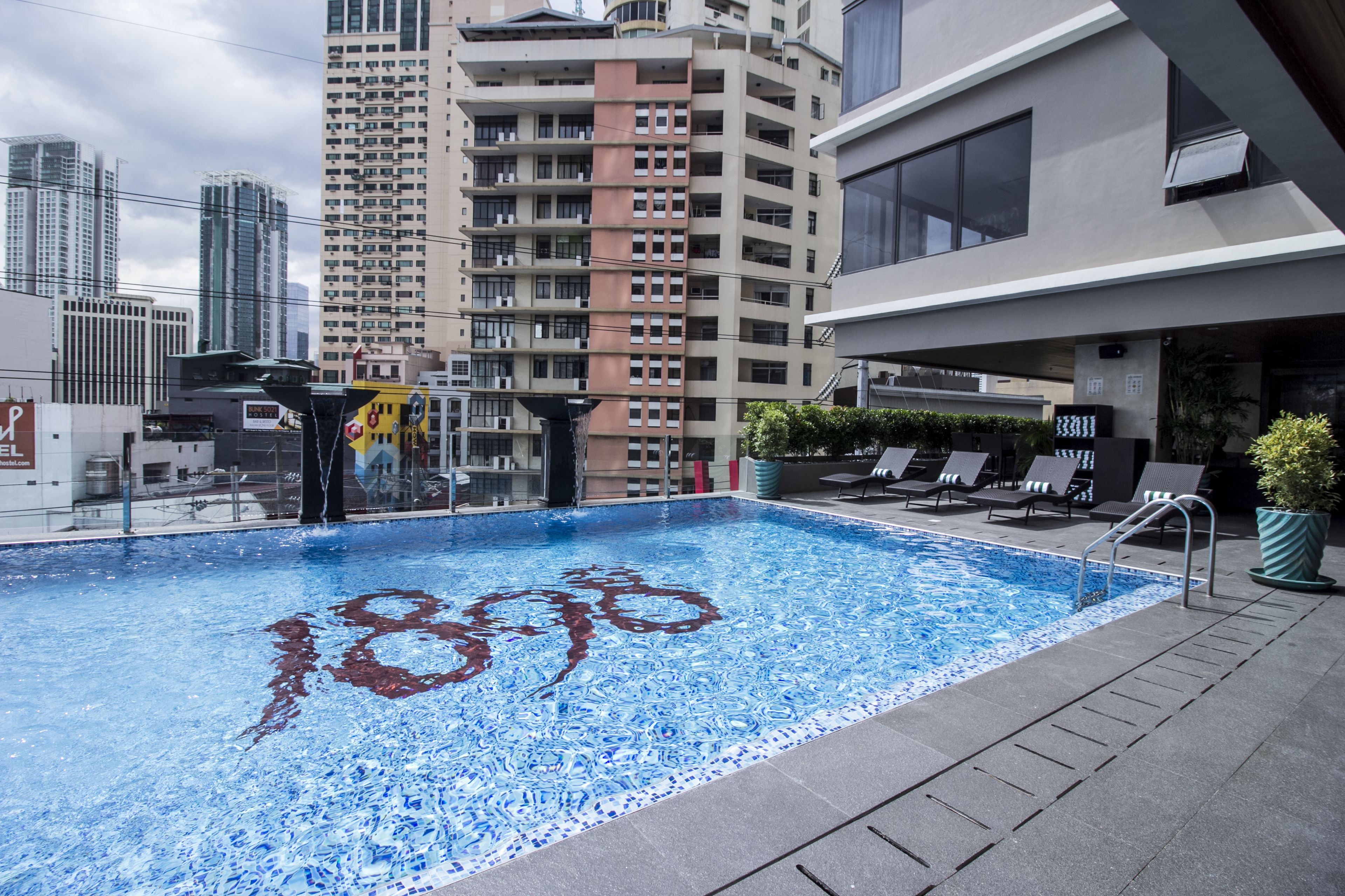 Piscina no terraço com vista para edifícios altos.