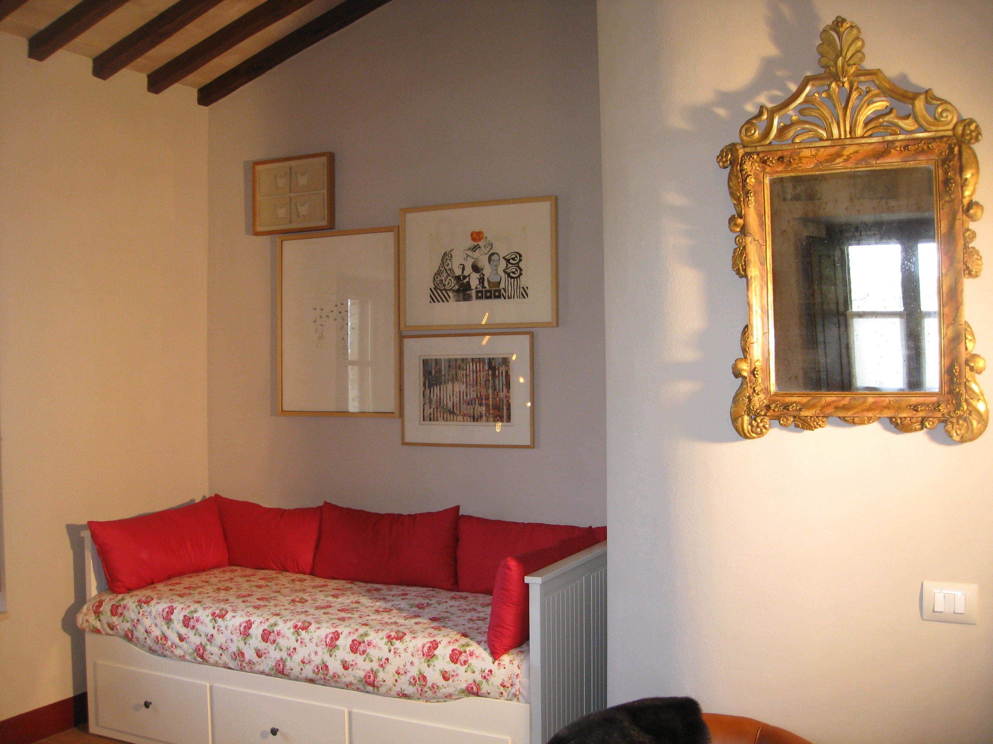 Um quarto com uma cama, cômoda e três quadros na parede.