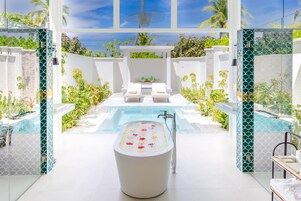 Um banheiro moderno com uma banheira independente, uma piscina pequena e um espaço de estar com vista para a piscina.
