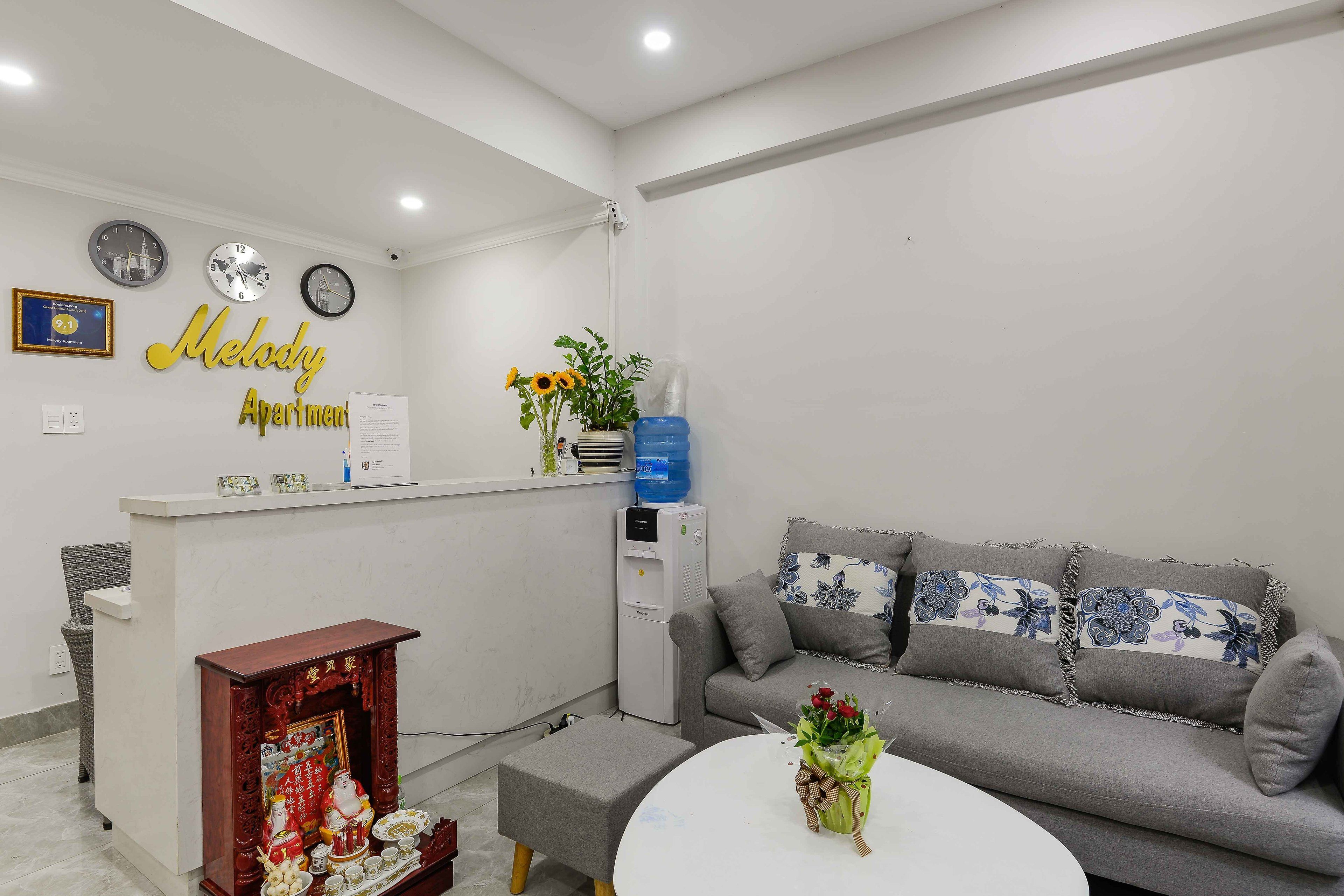 Uma sala de estar moderna com um sofá cinzento, uma mesa redonda pequena e um aparador decorativo com uma moldura.