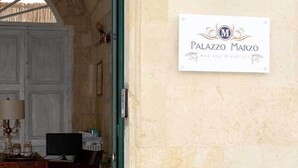 Entrada de um hotel com uma placa que diz 'Palazzo Marzo Red and Breakfast'.