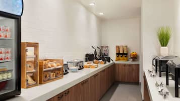 Um balcão de café da manhã limpo e moderno, com diversas opções de alimentos e uma estação de café.