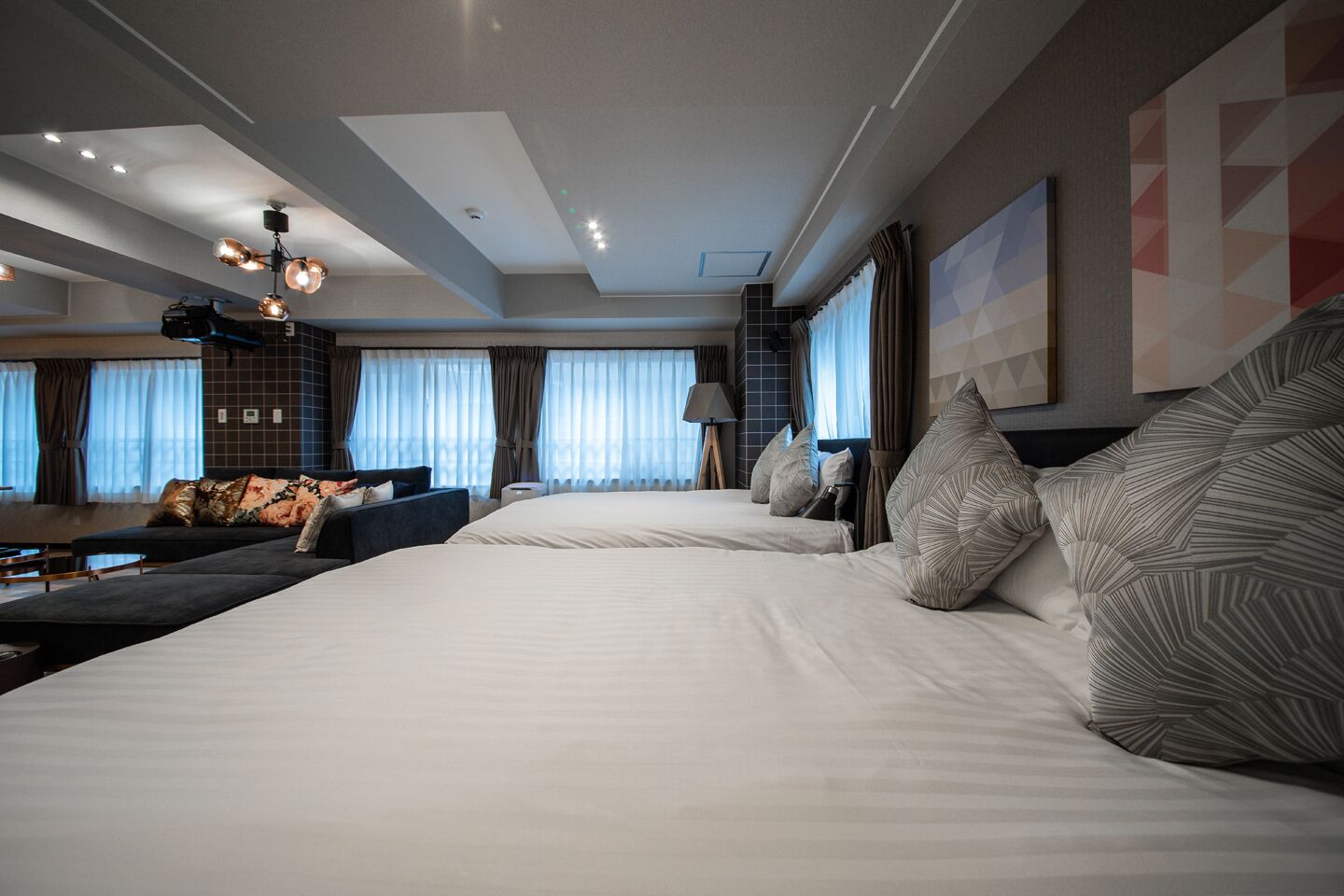 Quarto de hotel moderno com uma cama grande, um sofá e uma escrivaninha.