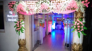 Uma área de recepção com um arco floral e uma placa indicando restaurante e banquetes.