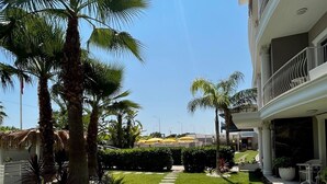 Um jardim bem cuidado com um caminho de pedra que leva a um edifício com varanda.
