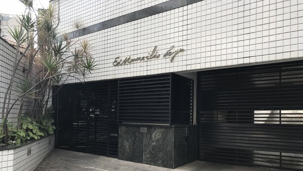 Um edifício com fachada em azulejos e uma placa com a inscrição 'Et Mounis El Ghan'.