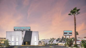 Hotel Hollywood Inn Suites, com design moderno, um estacionamento e céu claro.