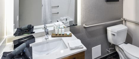 Um banheiro moderno com pia, espelho, porta-toalhas e vaso sanitário.
