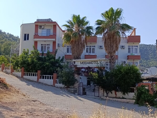 Um edifício de dois andares com uma placa que diz 'MODAMOTEL'.