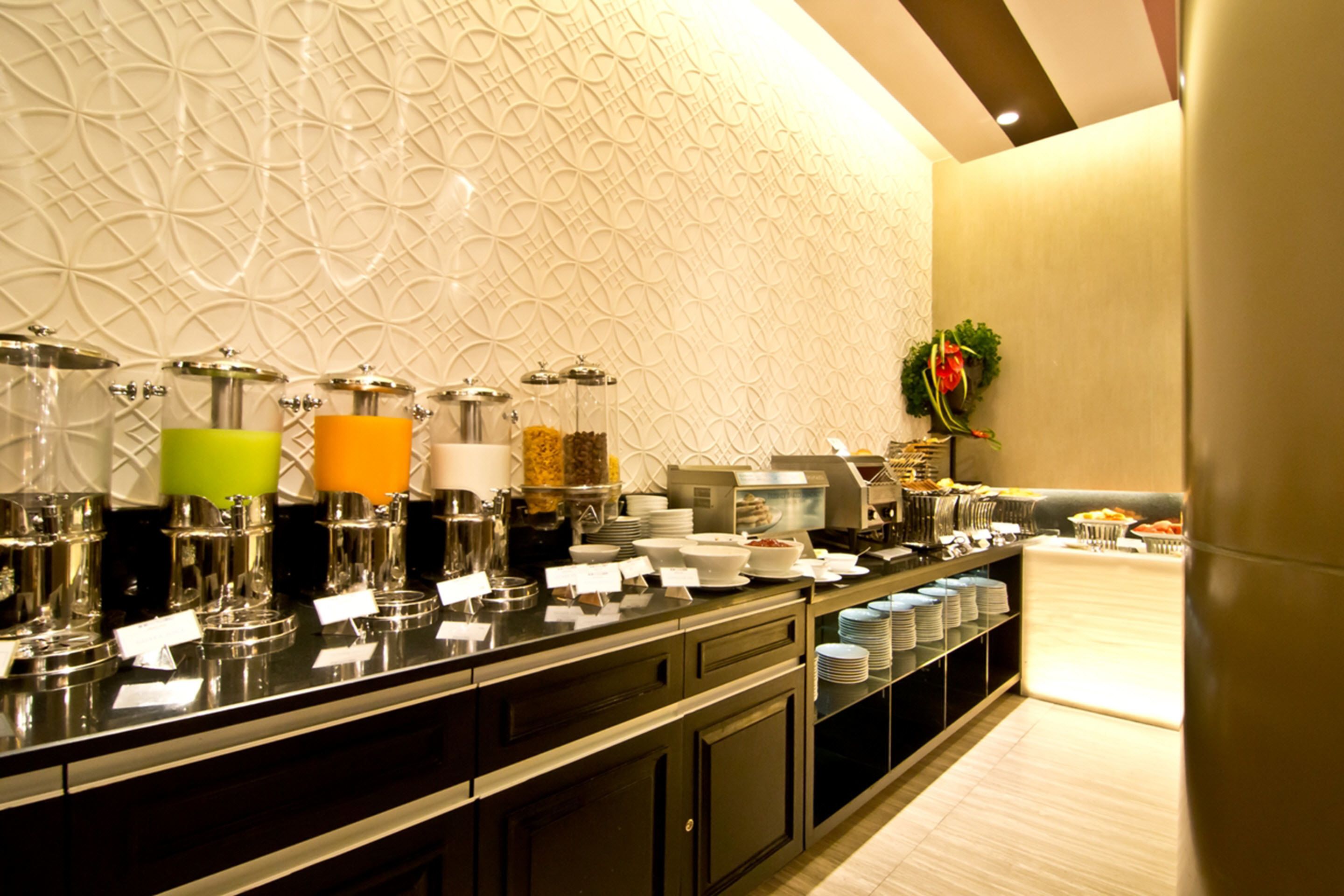 Uma mesa de buffet com diversas estações de comida e uma parede decorativa.