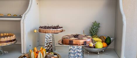Uma mesa de buffet com diversos doces e frutas.